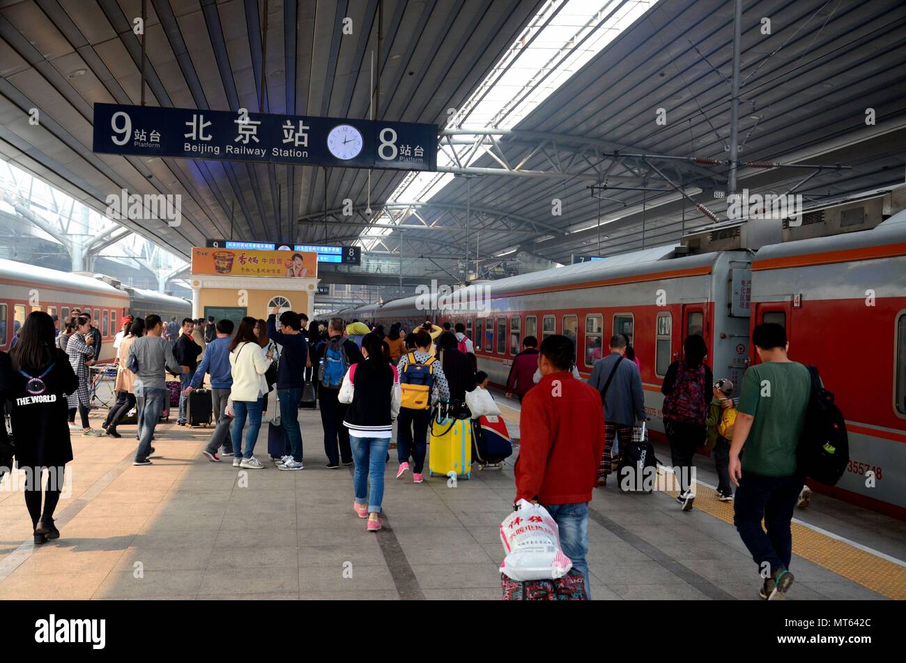 Busy platform with passengers and baggage exiting trains and greeting ...
