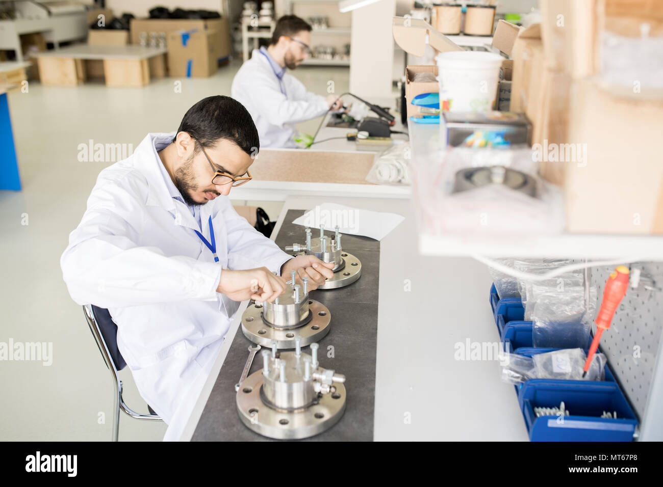 Technical assembler tightening bolts in workshop Stock Photo - Alamy