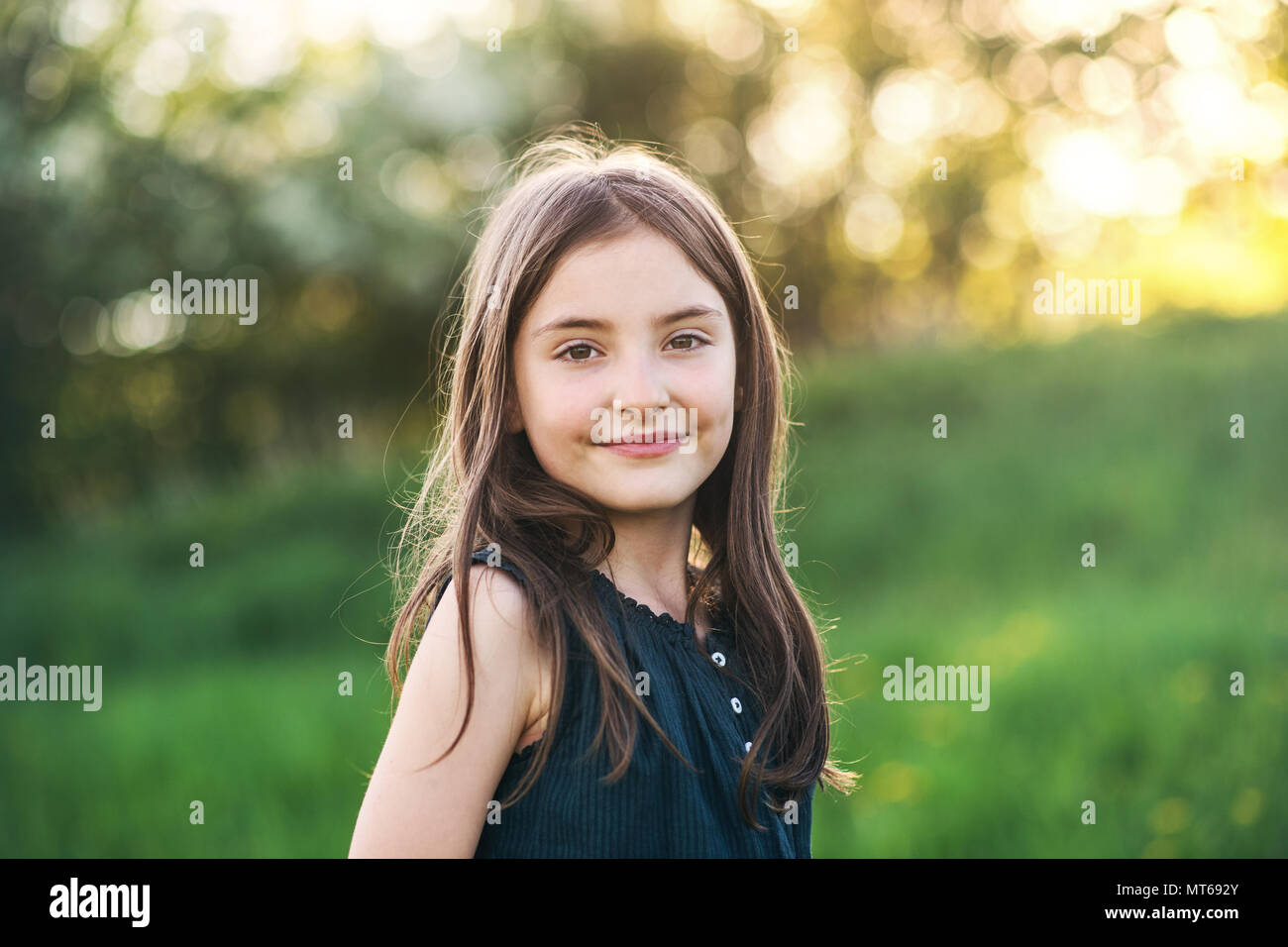A small girl standing outside in nature Stock Photo - Alamy