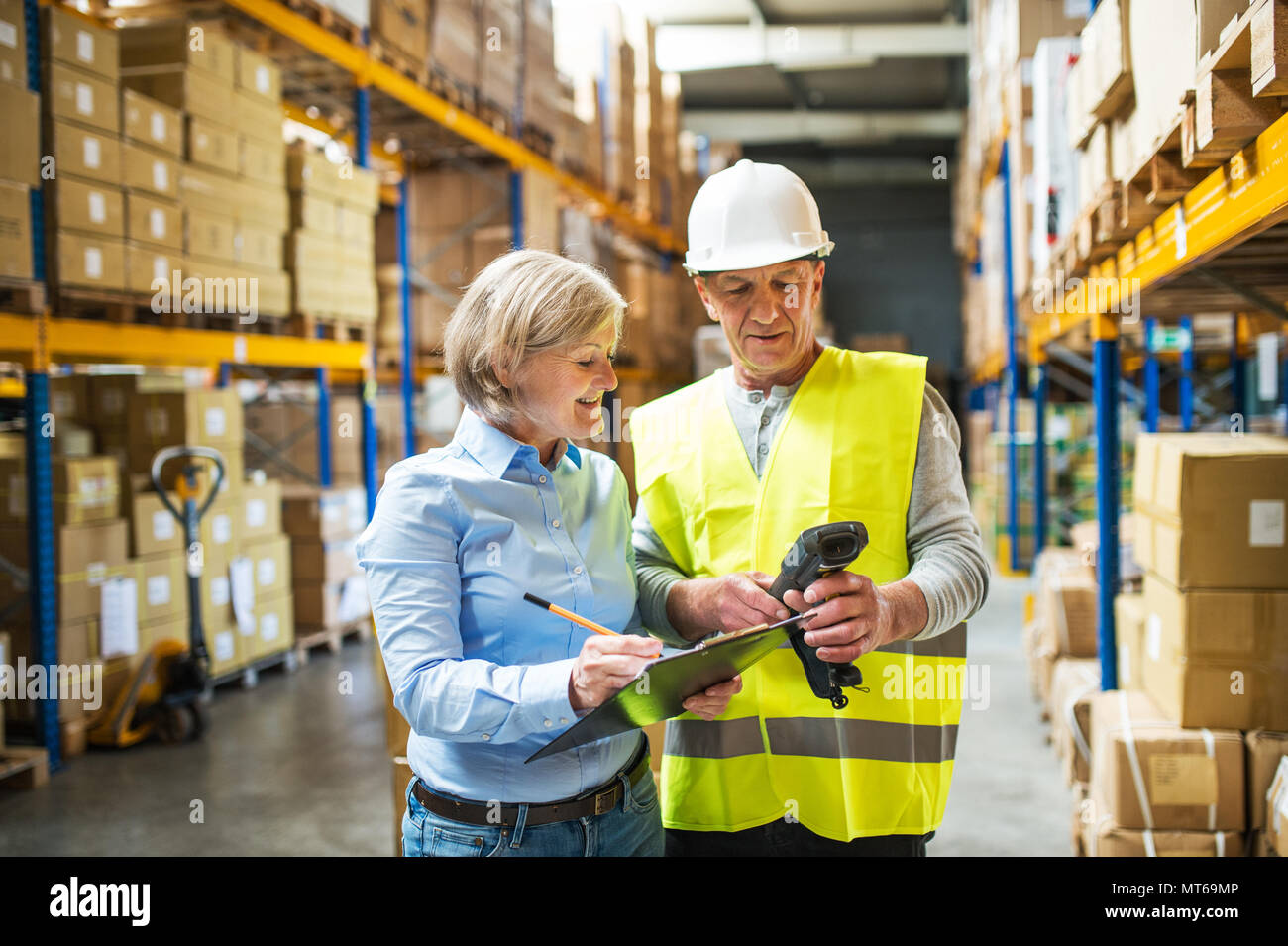 Senior woman manager and man worker working in a warehouse Stock Photo ...
