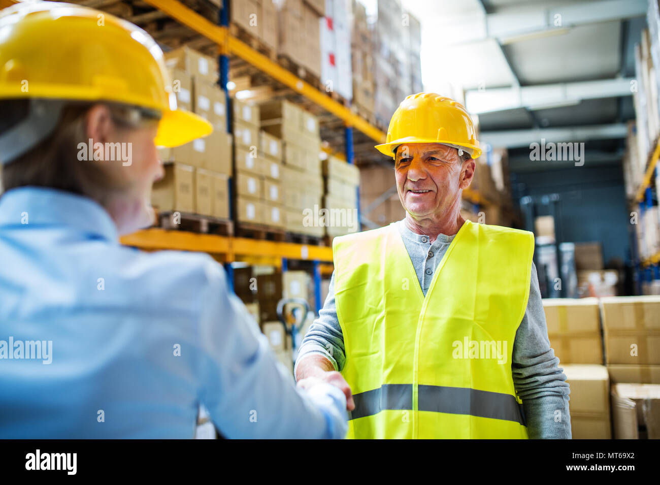 Senior woman manager and man worker working in a warehouse Stock Photo ...