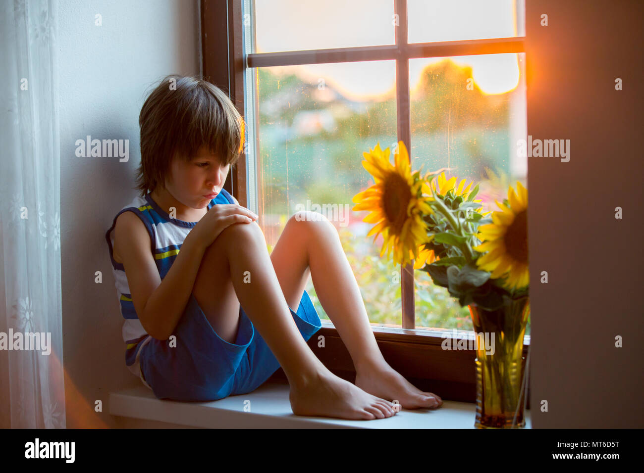 Sad cute little toddler child, playing with abacus on a window on ...