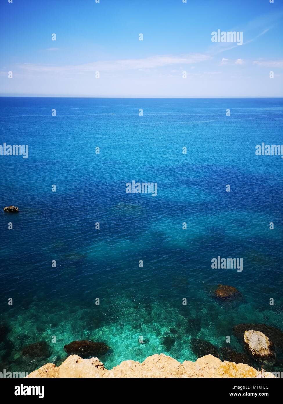 Rocky mediterranean seashore with azure and turquoise color water ...