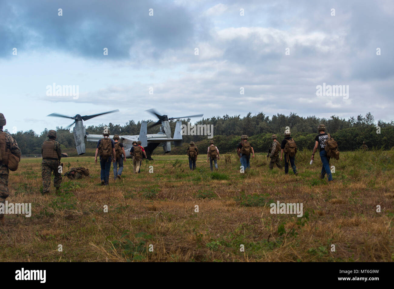 U.S. Marines and role players prepare to board an MV-22 Osprey aircraft ...