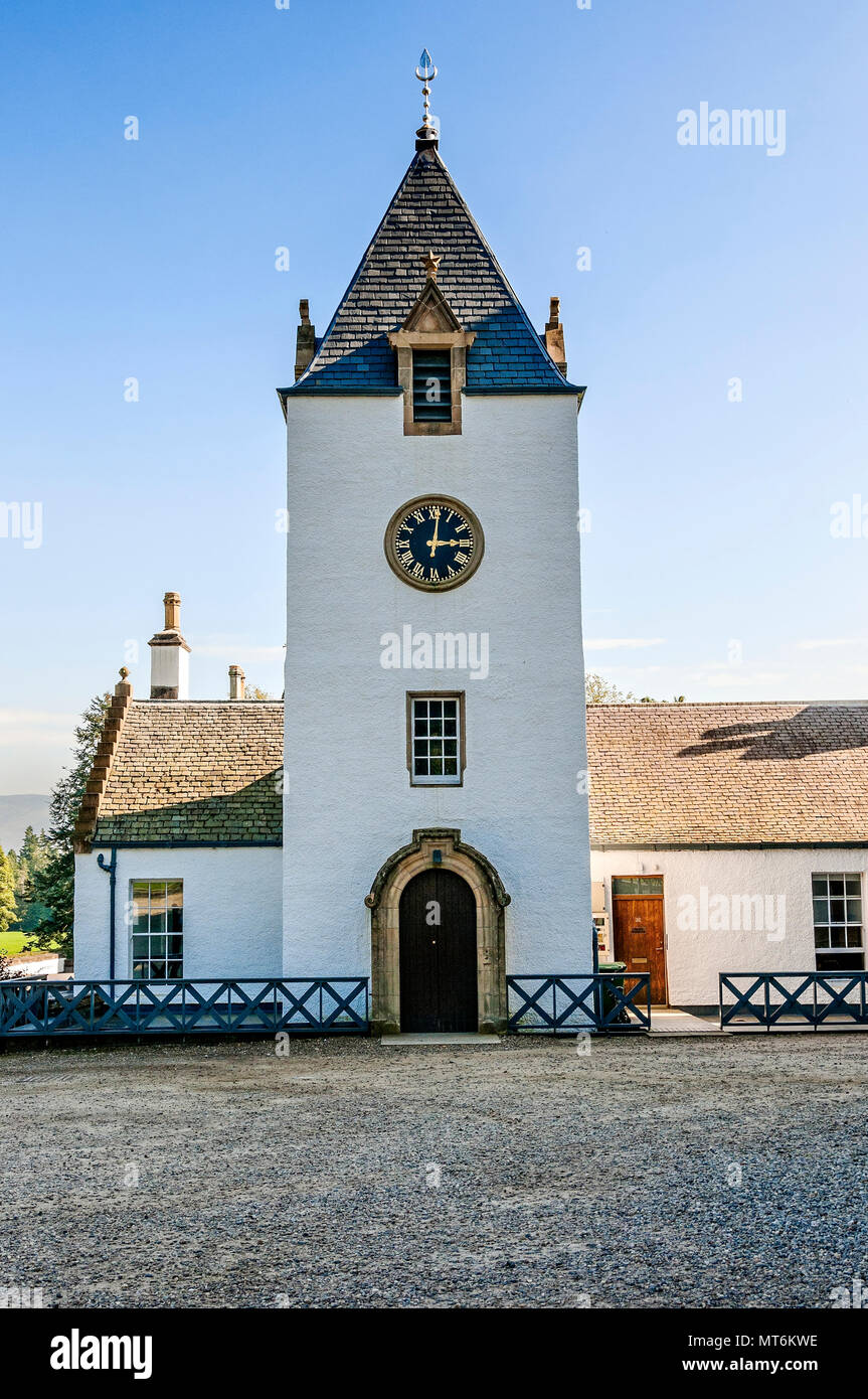 A tiled pinnacle roof containing louvered windows tops a tall white ...