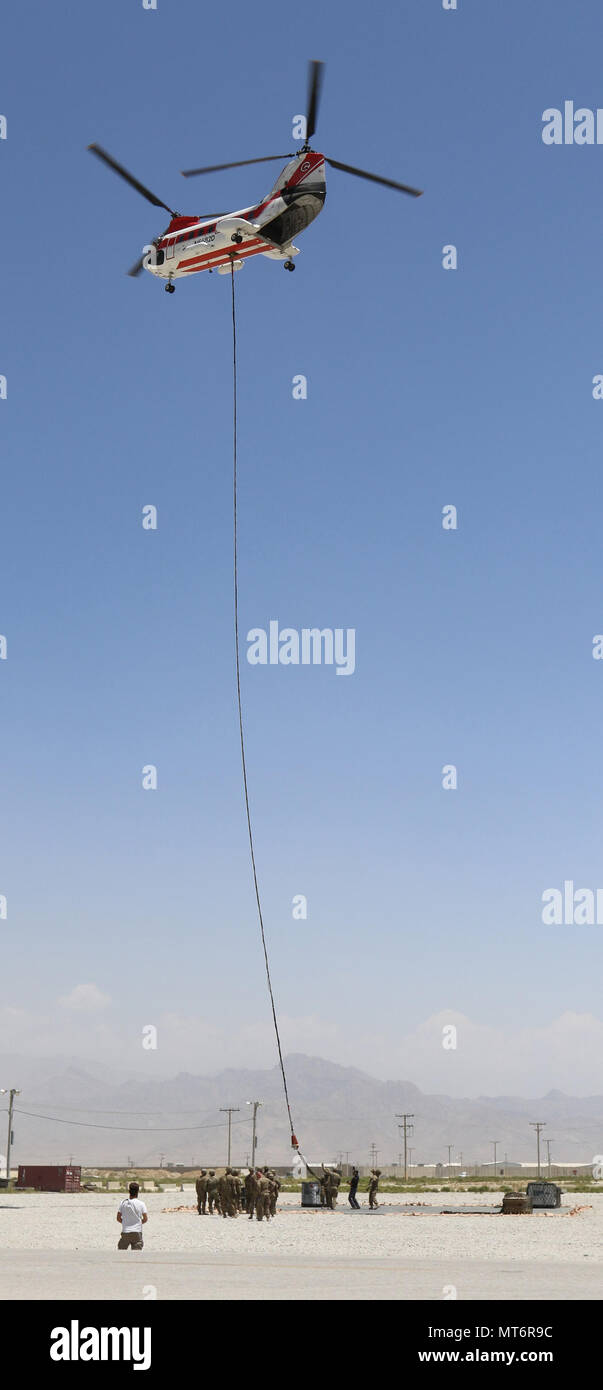 A 100 foot line [long line] hangs from the belly of a helicopter as ...