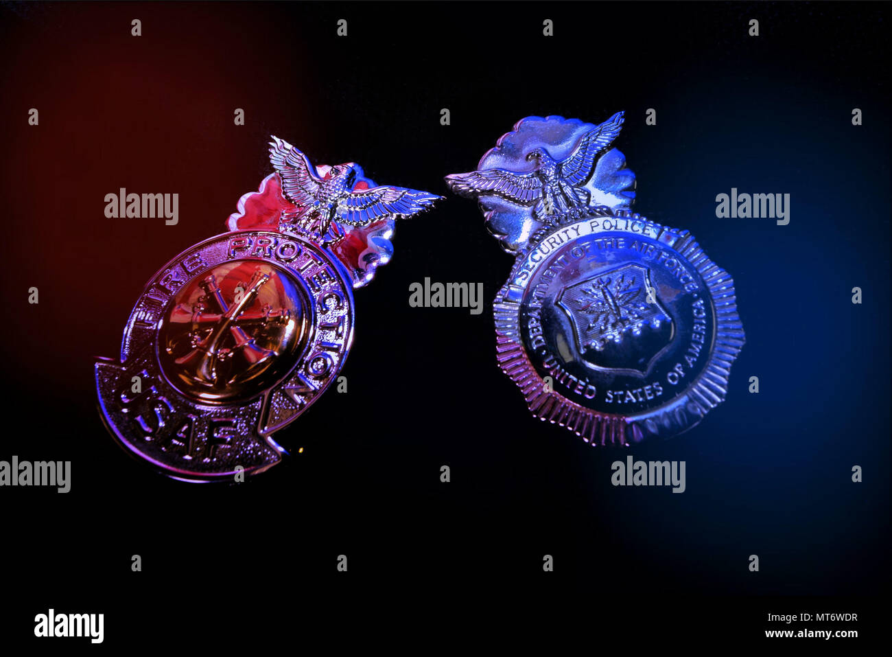 A fire protection badge and a security forces badge lie next to each ...