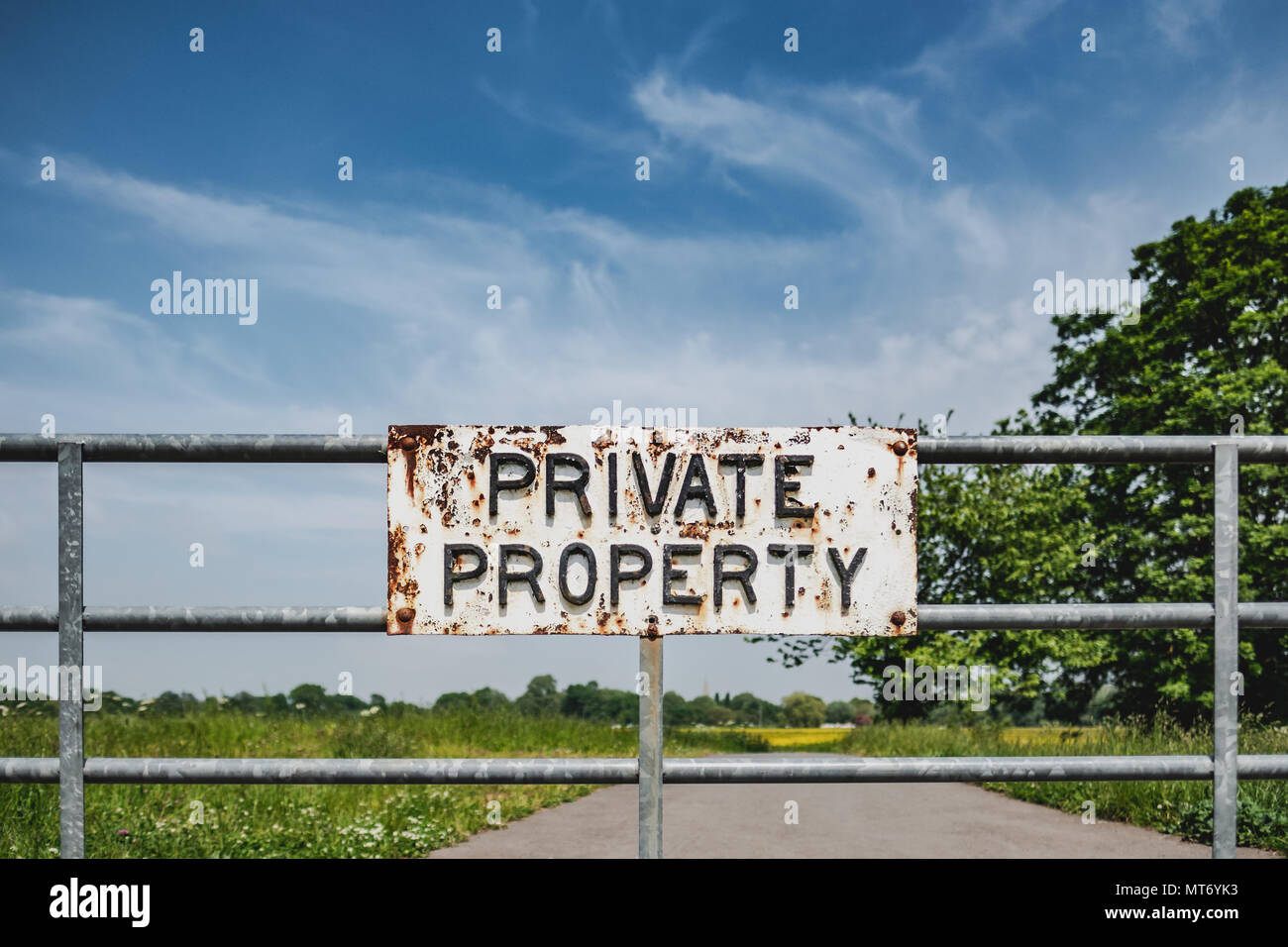 Shut and locked farm gate showing an improvised and rusting Private ...