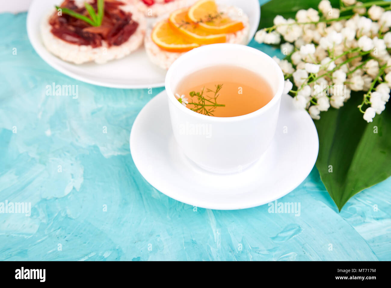 Breakfast - tea, rice crispbread with fresh fruits on blue background ...