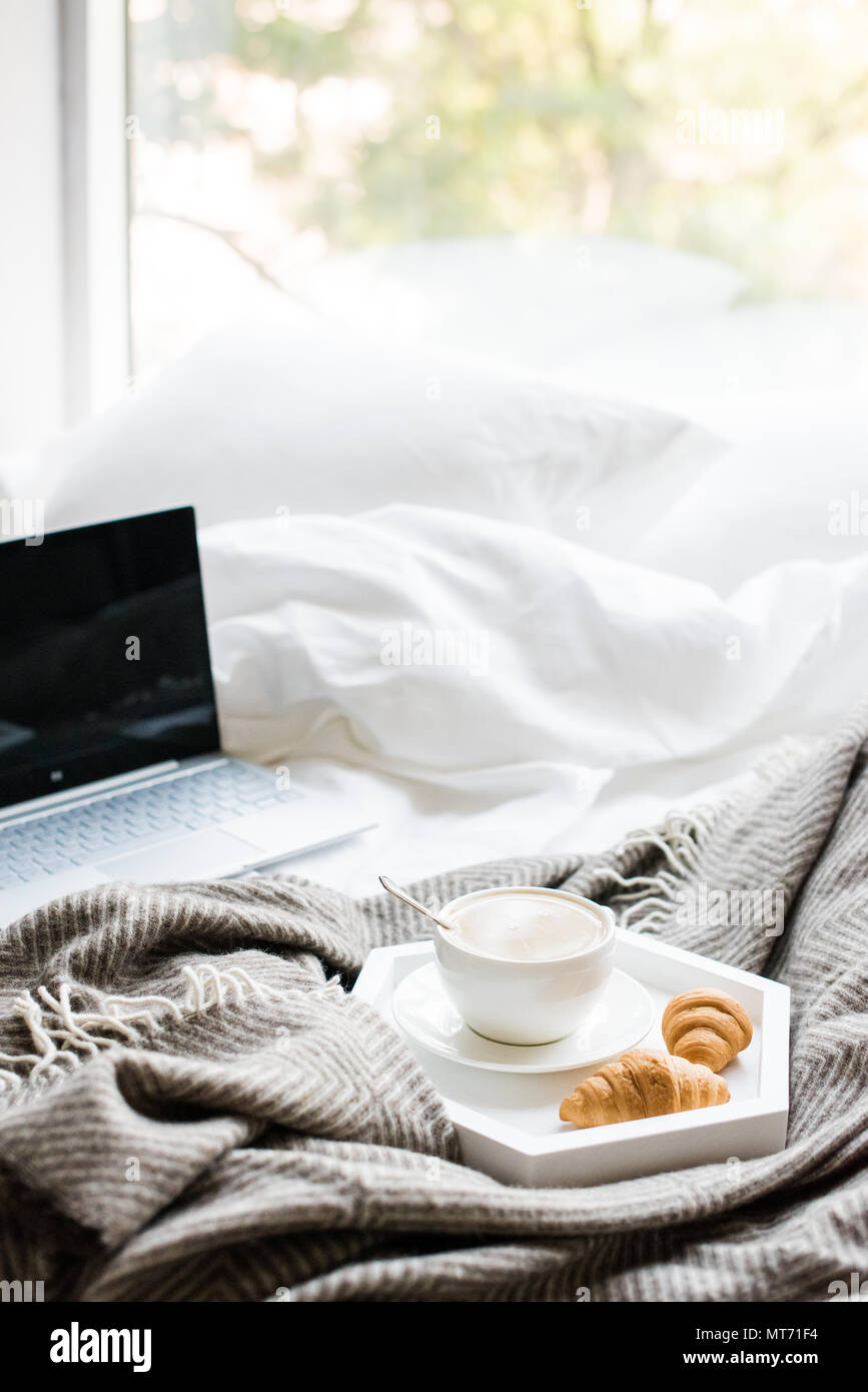 Cozy weekend at home, laptop and coffee in bed, freelancers breakfast ...
