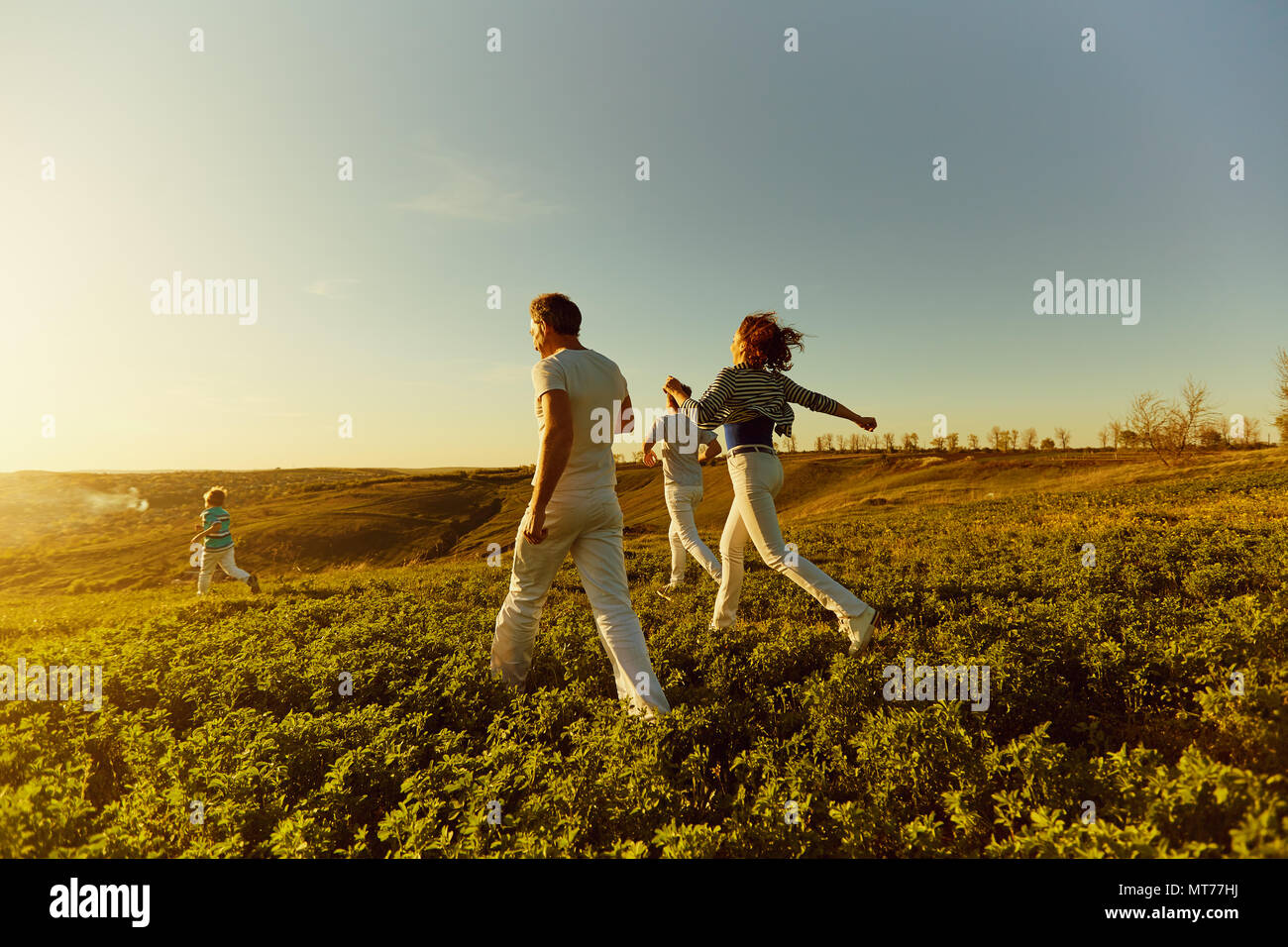 Family running across field together hi-res stock photography and ...