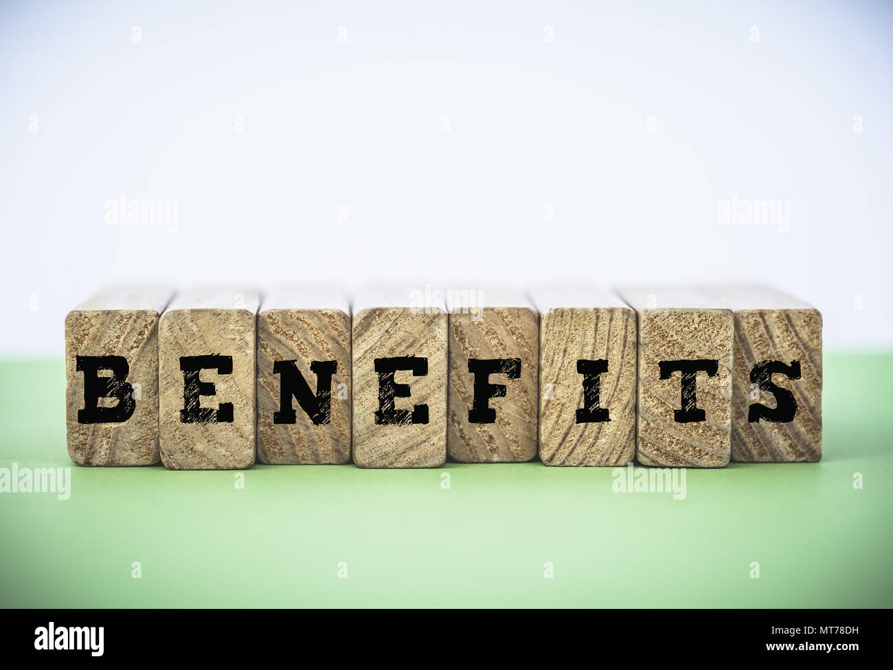 BENEFITS word made from building blocks on green and white background ...