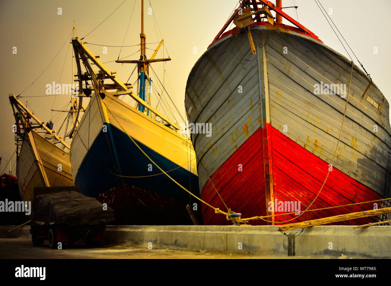 Fisherman and sailor enjoying sunset at a traditional ship boat docking ...