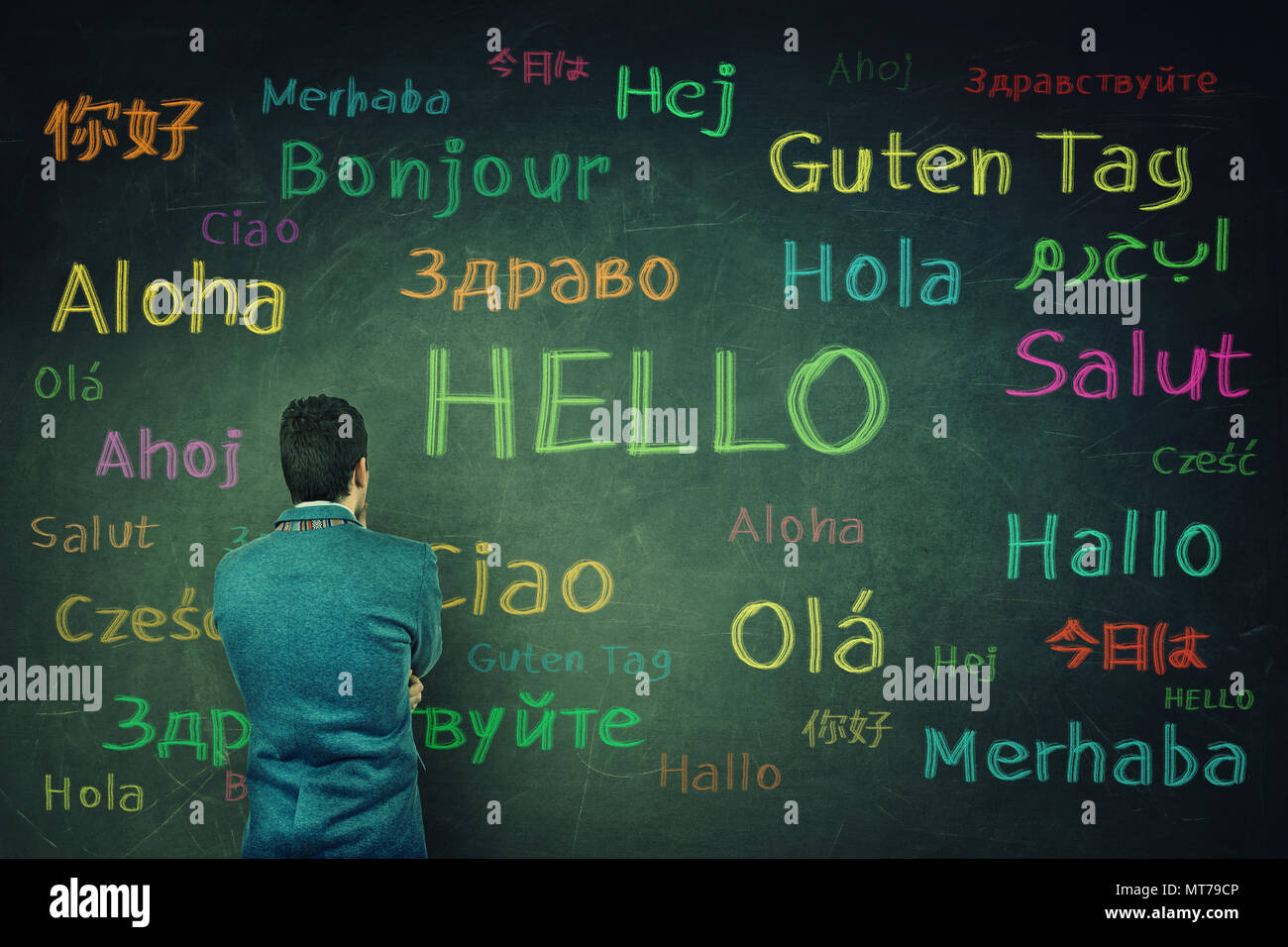 Rear view of a puzzled businessman in front of a huge chalkboard ...