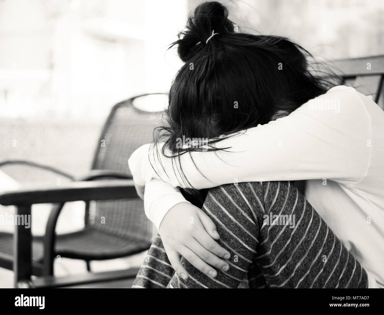 Black and white of sad and depressed little girl sitting on chair Stock ...