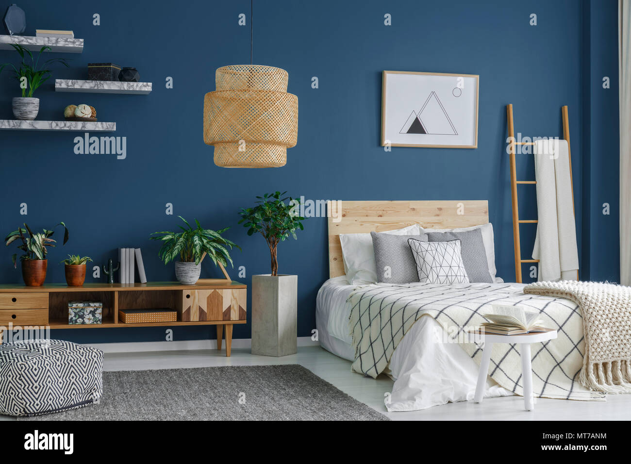 Side view of a blue bedroom interior with a modern lamp, double bed ...