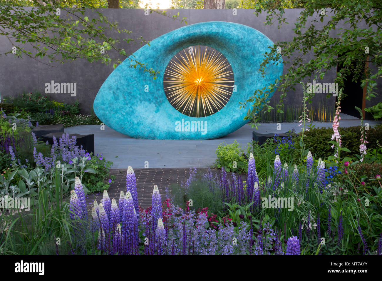 A dramatic sculpture surrounded by plants including Lupinus ‘West ...