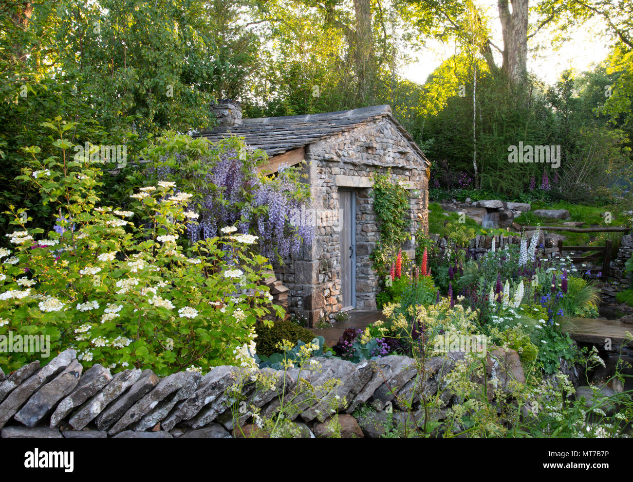 A traditional cottage style garden surrounding a stone bothy in the ...