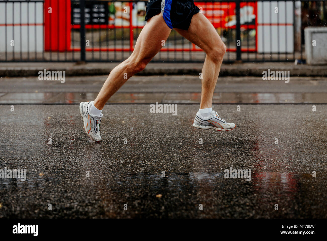 foot men runner running on wet from rain gray asphalt Stock Photo - Alamy