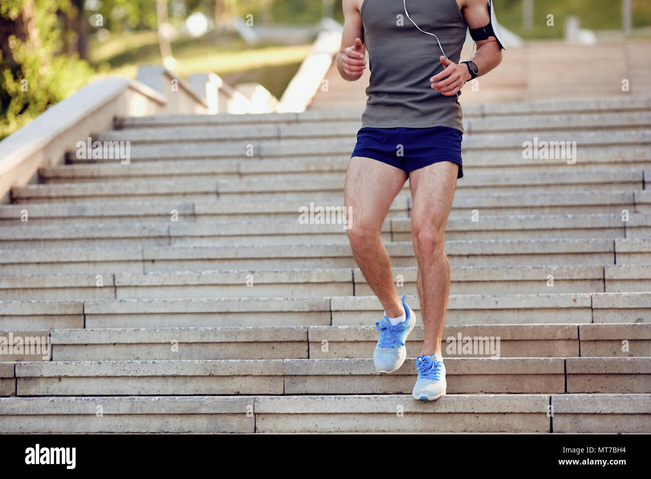 A male runner runs down the steps in the park Stock Photo - Alamy