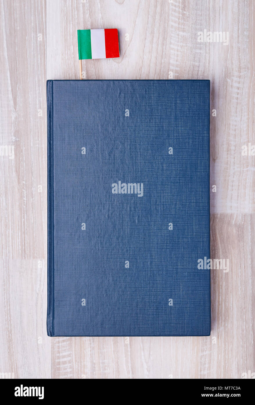 Flat lay of blue textured notepad with Italian flag on toothpick as ...