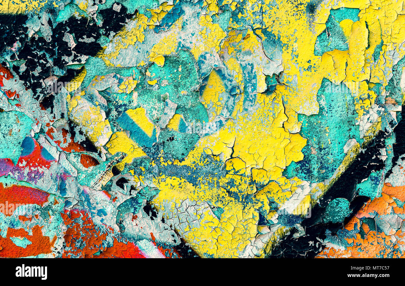 Cracked and peeling sprayed paint of an old wall of abandoned building ...