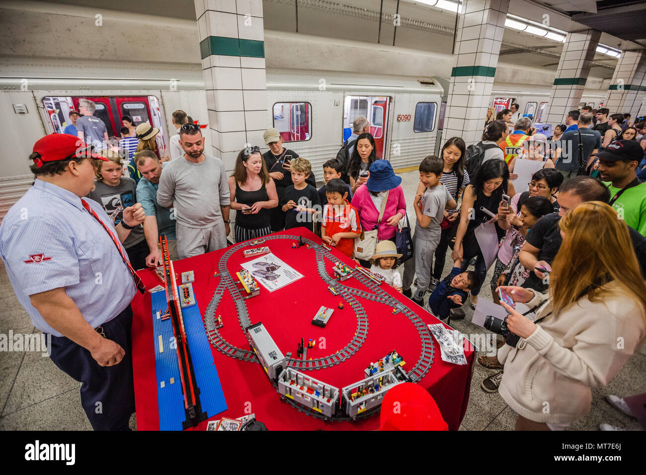 People gather around a lego train set by built by the toronto transit ...