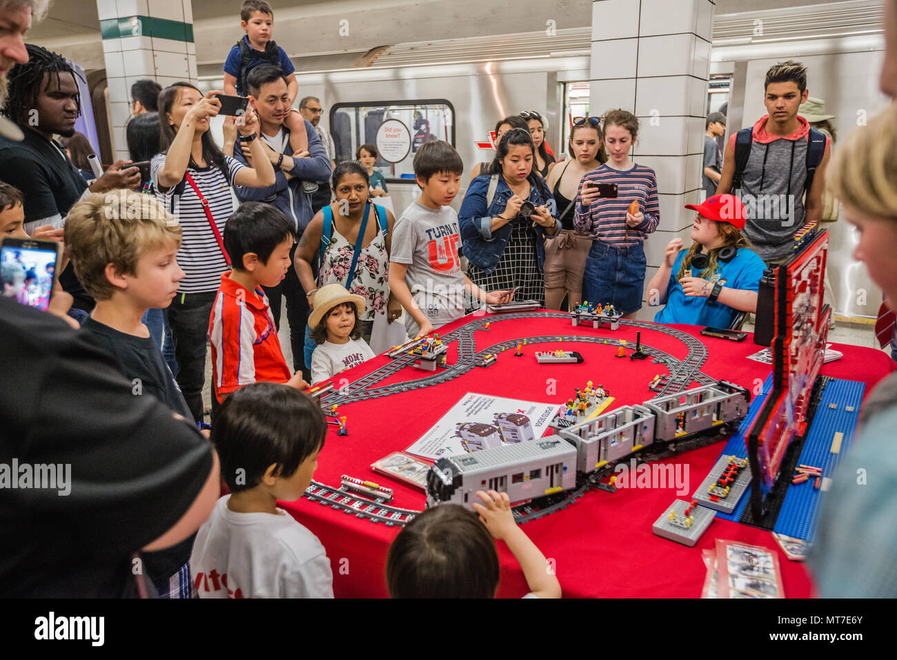People gather around a lego train set by built by the toronto transit ...