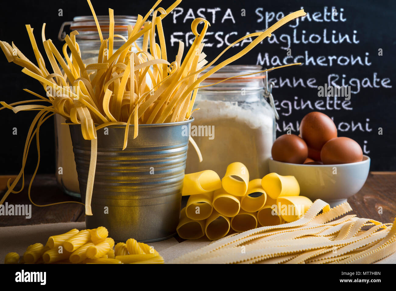 Assortment of homemade fresh egg pasta with a blackboard background ...