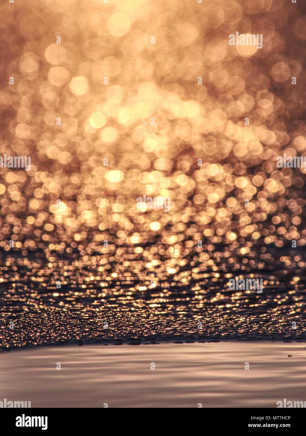 Sharp edge of dark water thawed from under the prurple blue ice in ...