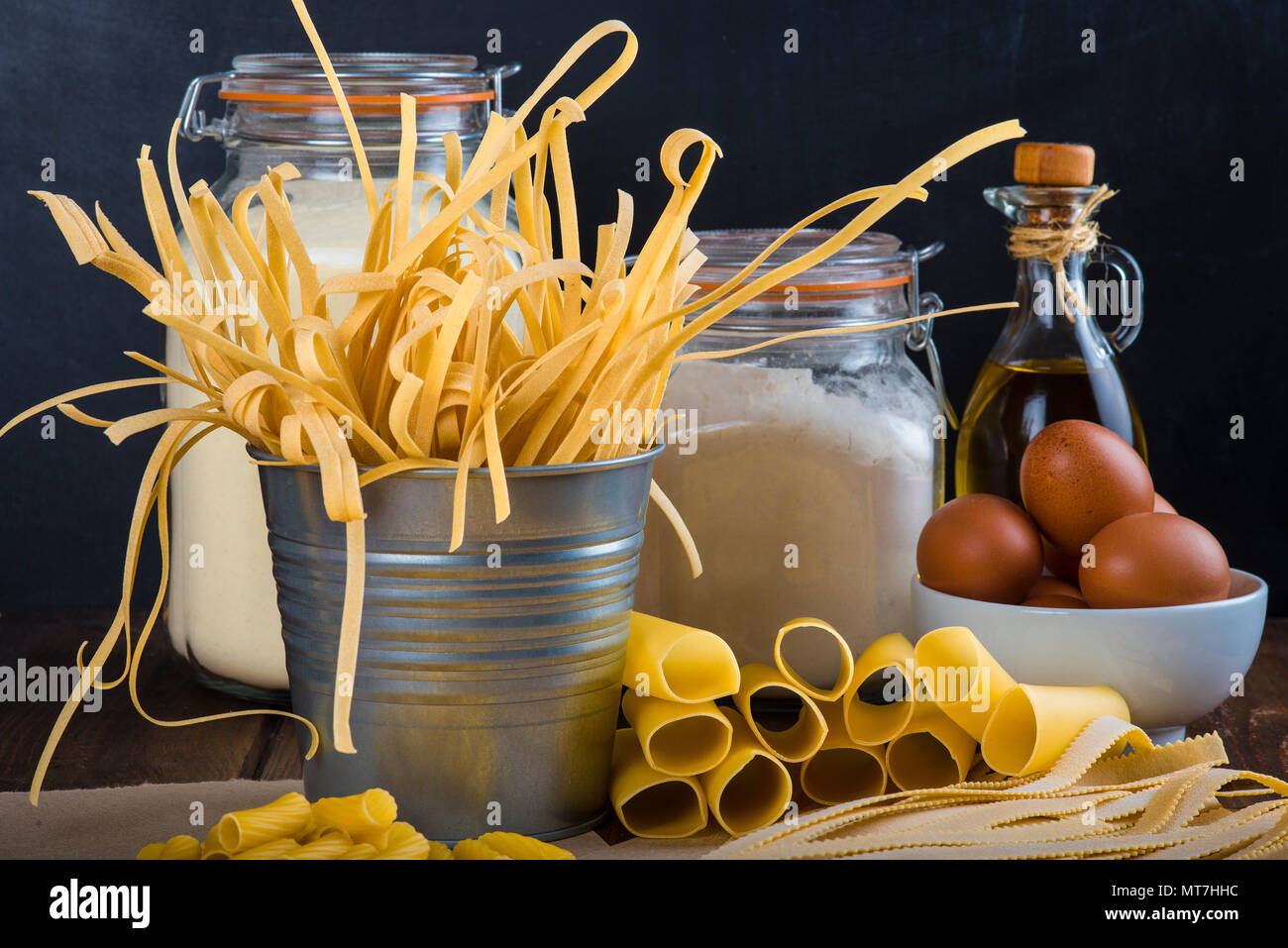 Assortment of homemade fresh egg pasta with a blackboard background ...