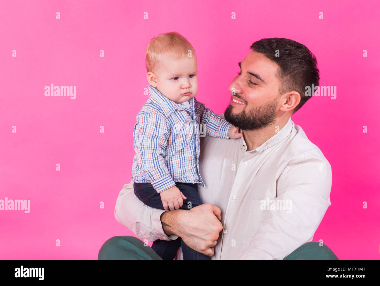 Happy father with his baby son on pink background Stock Photo - Alamy
