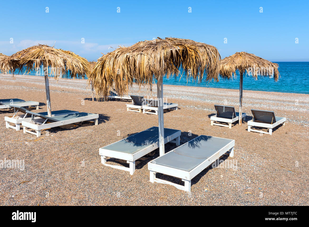 Sun loungers with umbrellas on sandy and pebble Kalathos beach. Rhodes ...