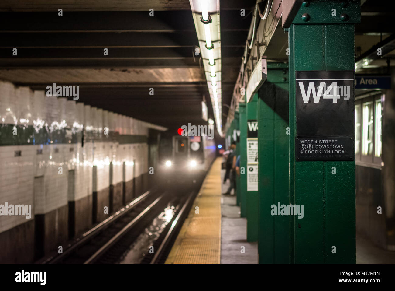 A train approaching the platform at West 4th Street subway station in Manhattan, New York City ...