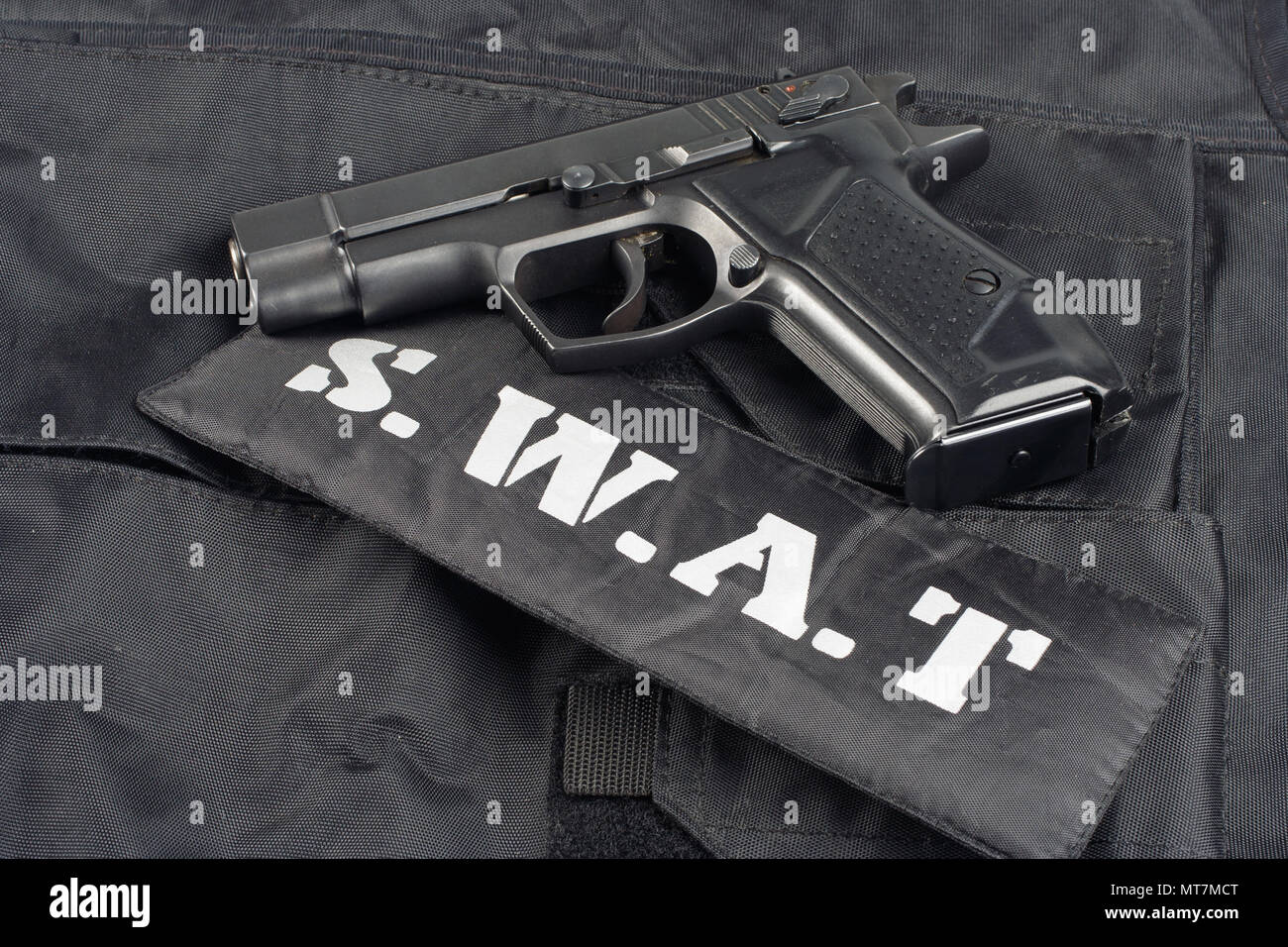SWAT teams concept -handgun on black uniform background Stock Photo - Alamy
