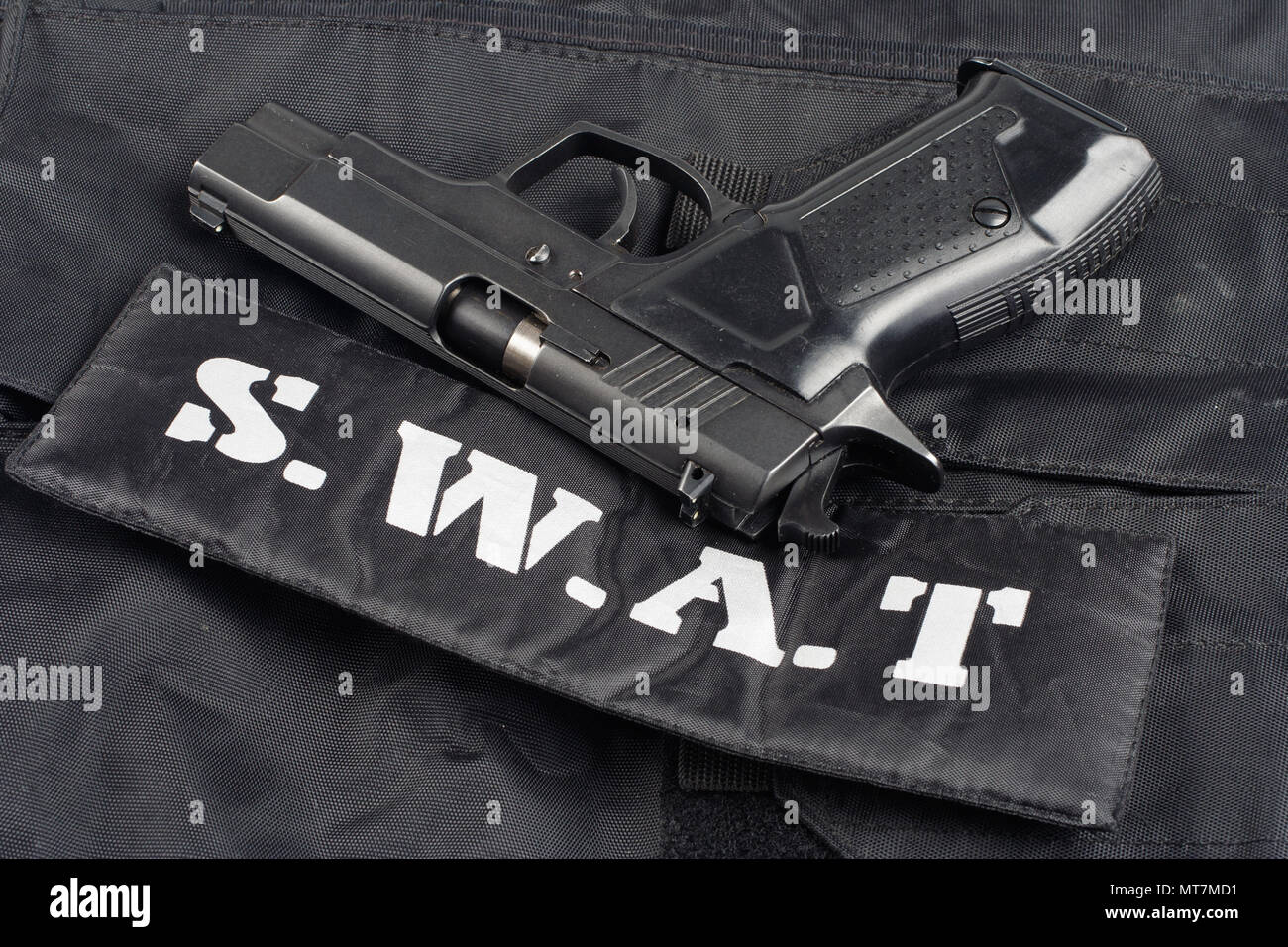 SWAT teams concept -handgun on black uniform background Stock Photo - Alamy