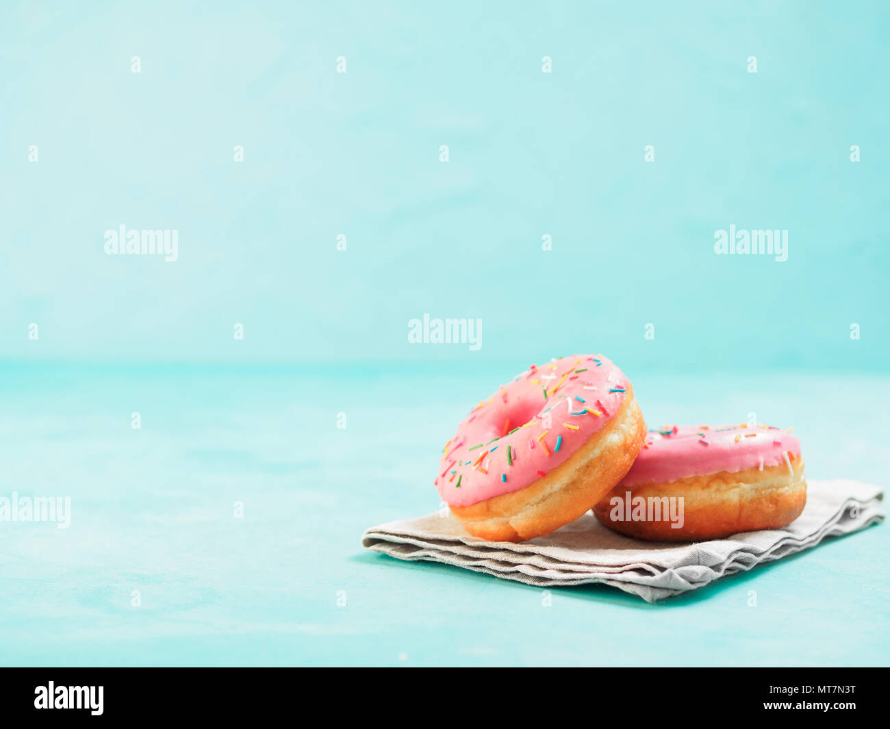 Two pink donuts on blue concrete background with copy space. Colorful ...