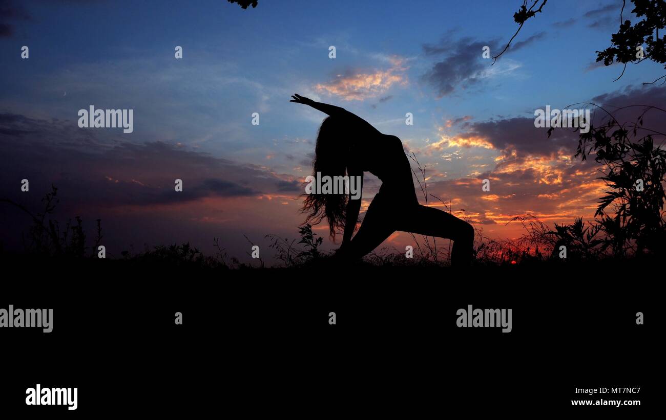 Woman shadow doing yoga, female silhouette in evening sky background ...