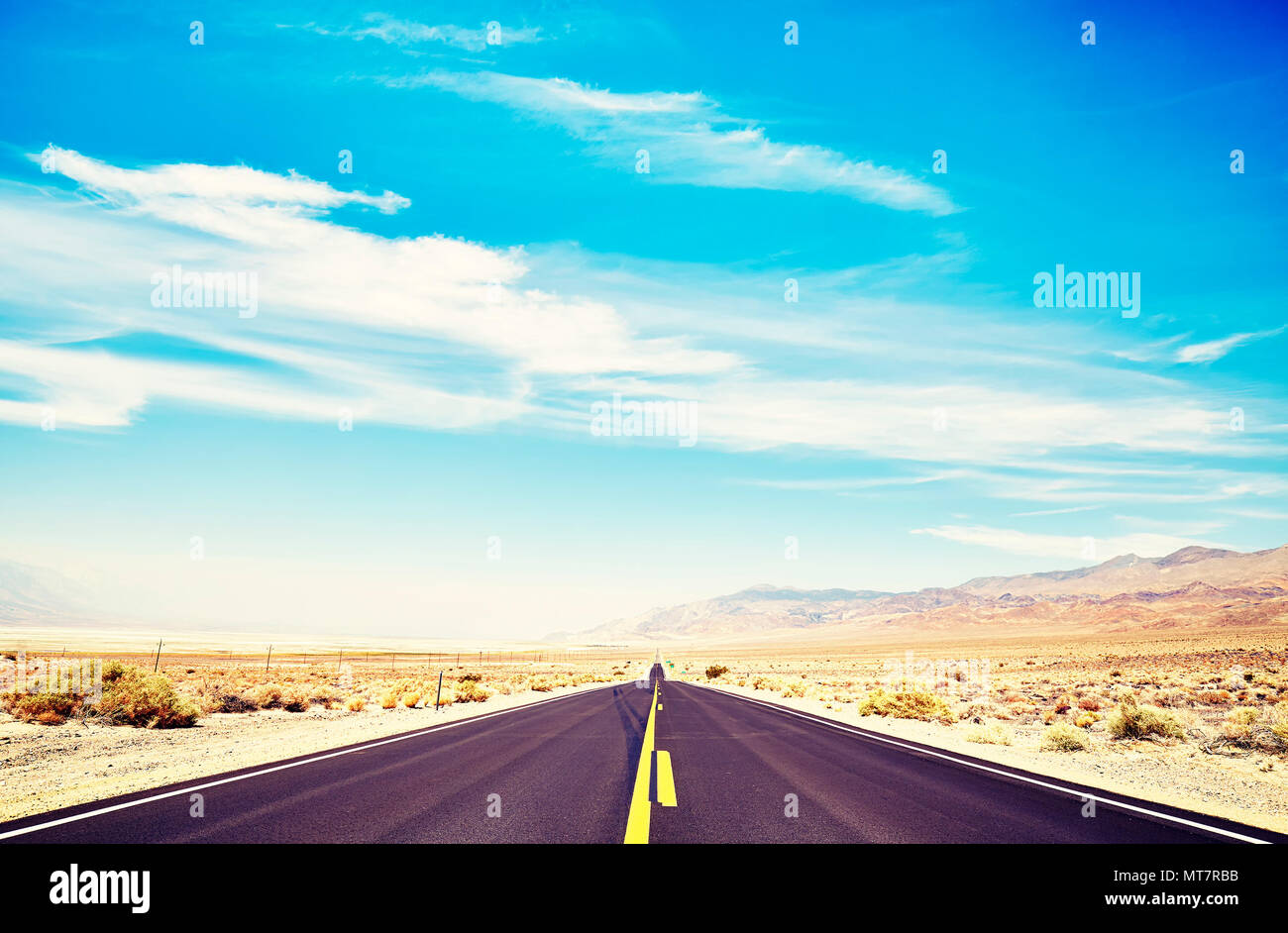 Endless desert road in the Death Valley, color toned picture ...