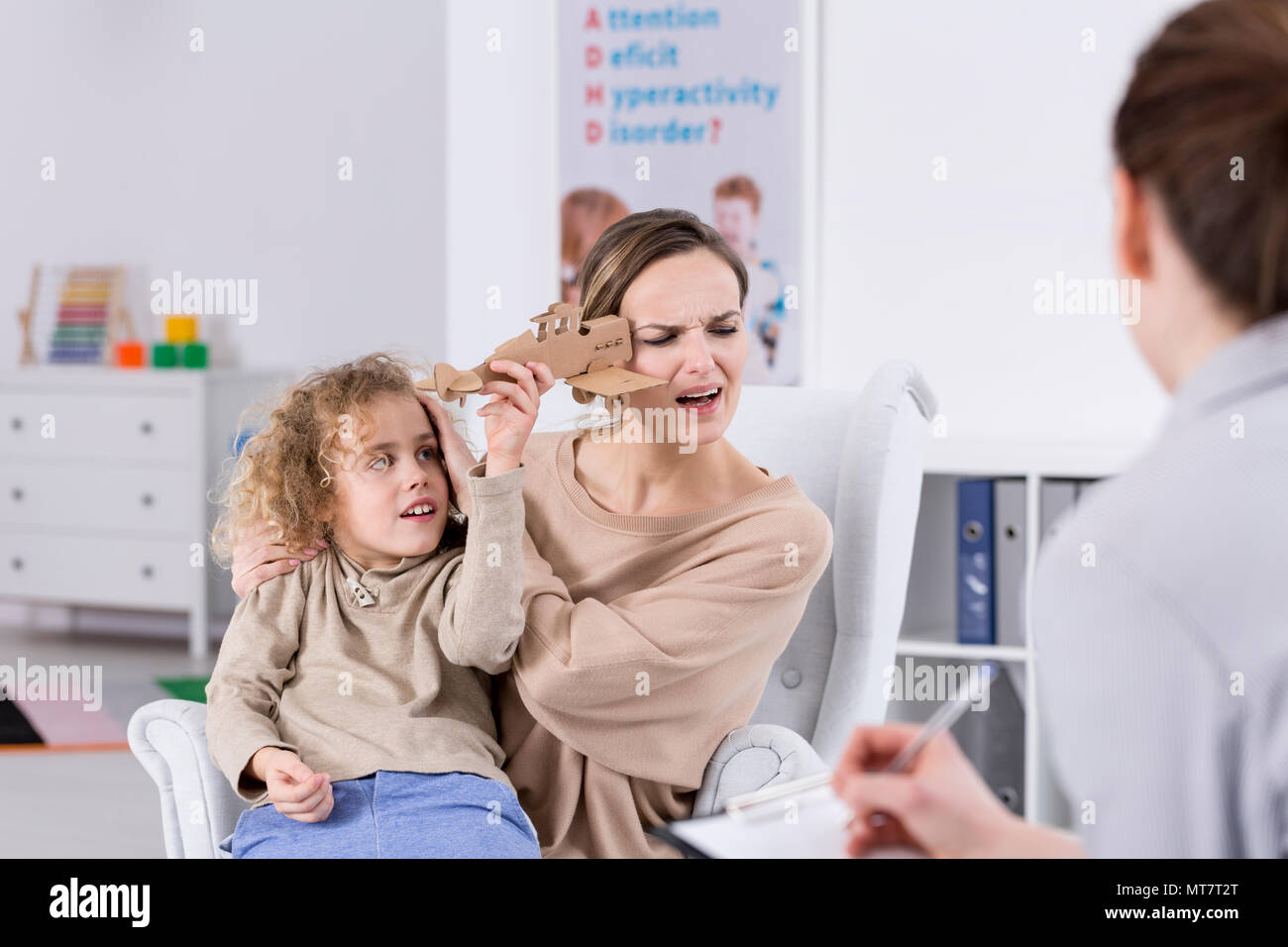 ADHD child annoying his mother at psychologist office Stock Photo - Alamy