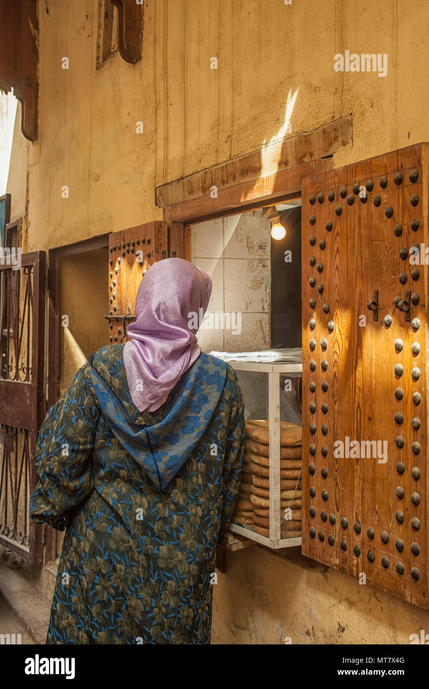Moroccan lady with scarf buying bread in the medina of Rabat Stock ...