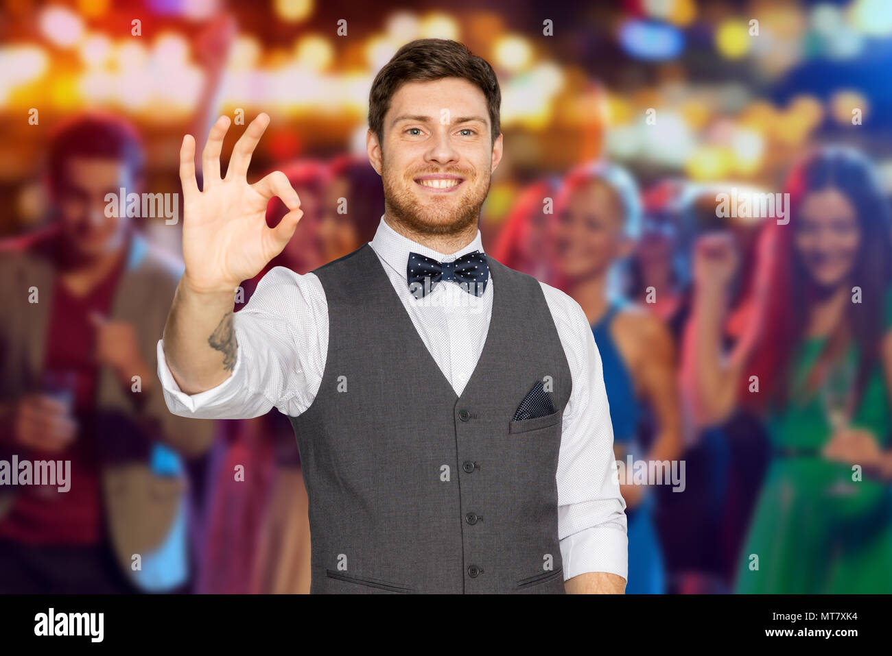 man in suit showing ok sign over night club party Stock Photo - Alamy