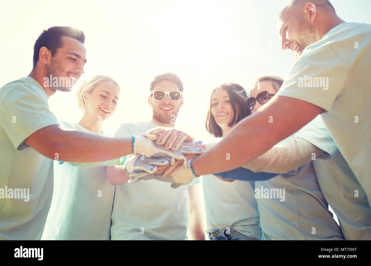 group of volunteers putting hands on top outdoors Stock Photo - Alamy