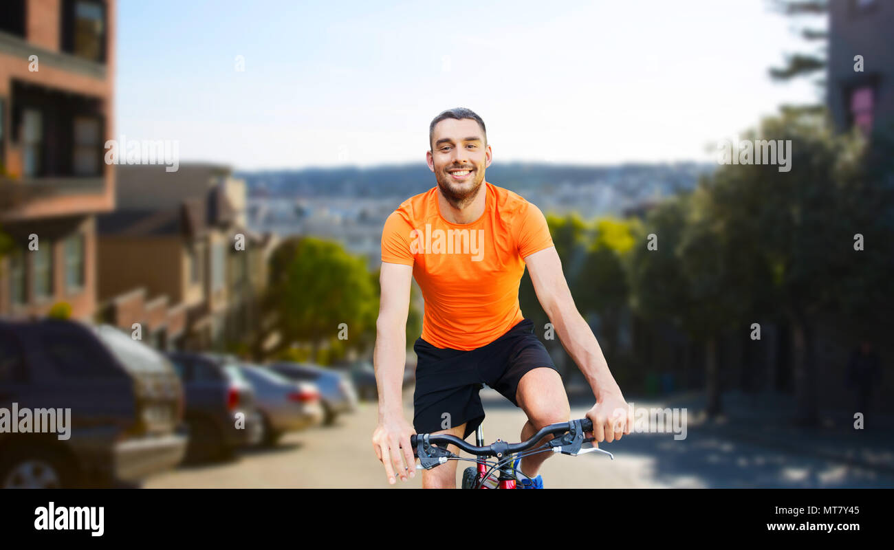 happy man riding bicycle over san francisco city Stock Photo - Alamy