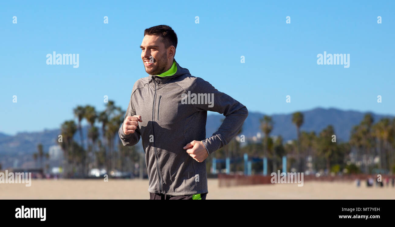 happy young man running over venice beach Stock Photo - Alamy