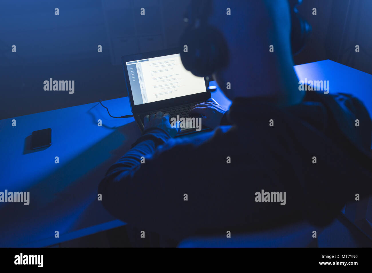 hacker with coding on laptop computer in dark room Stock Photo - Alamy