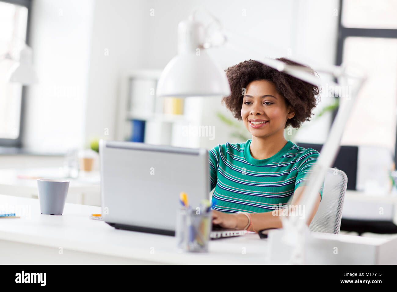 happy african woman with laptop computer at office Stock Photo - Alamy