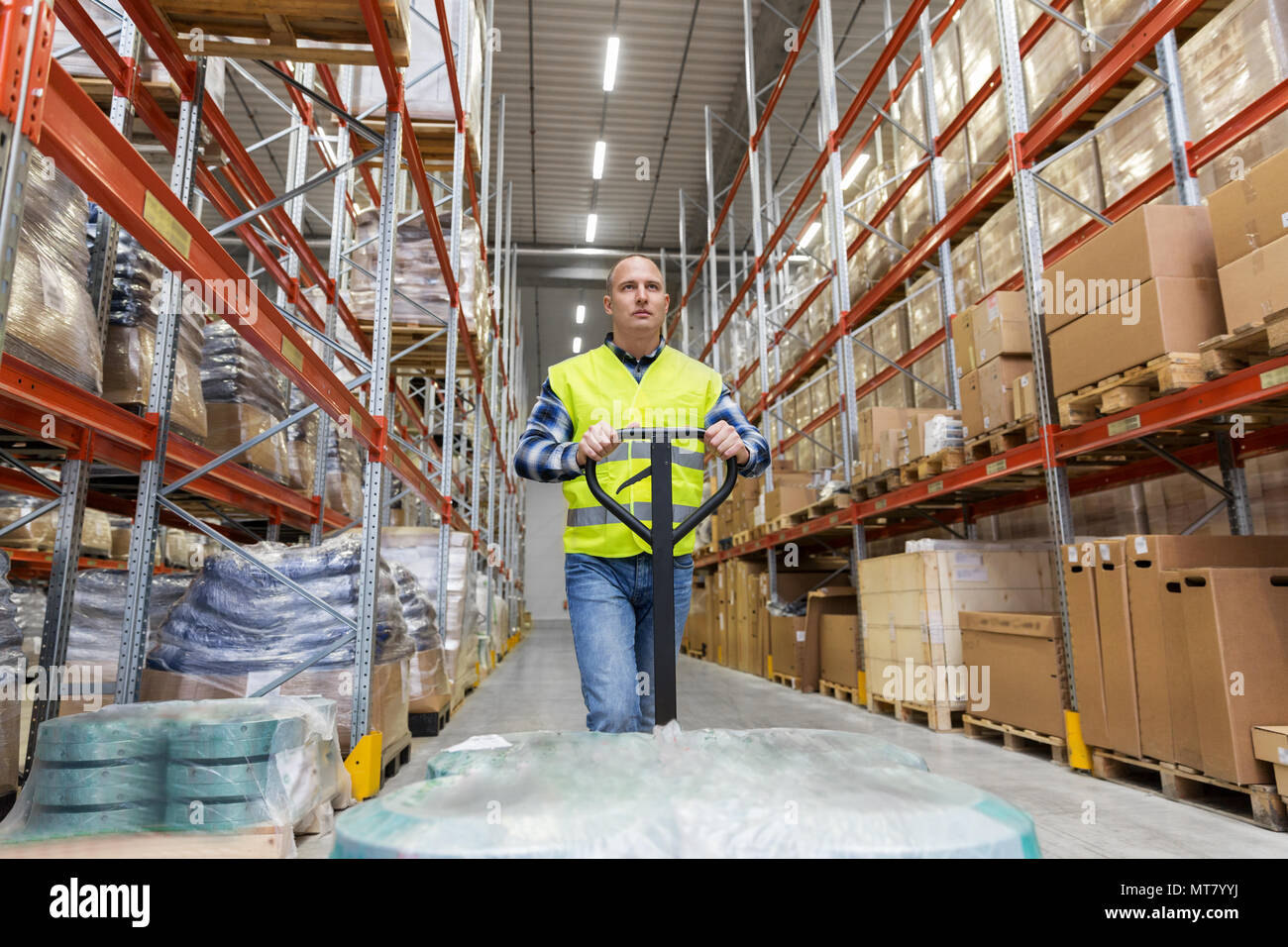 warehouse worker carrying loader with goods Stock Photo - Alamy