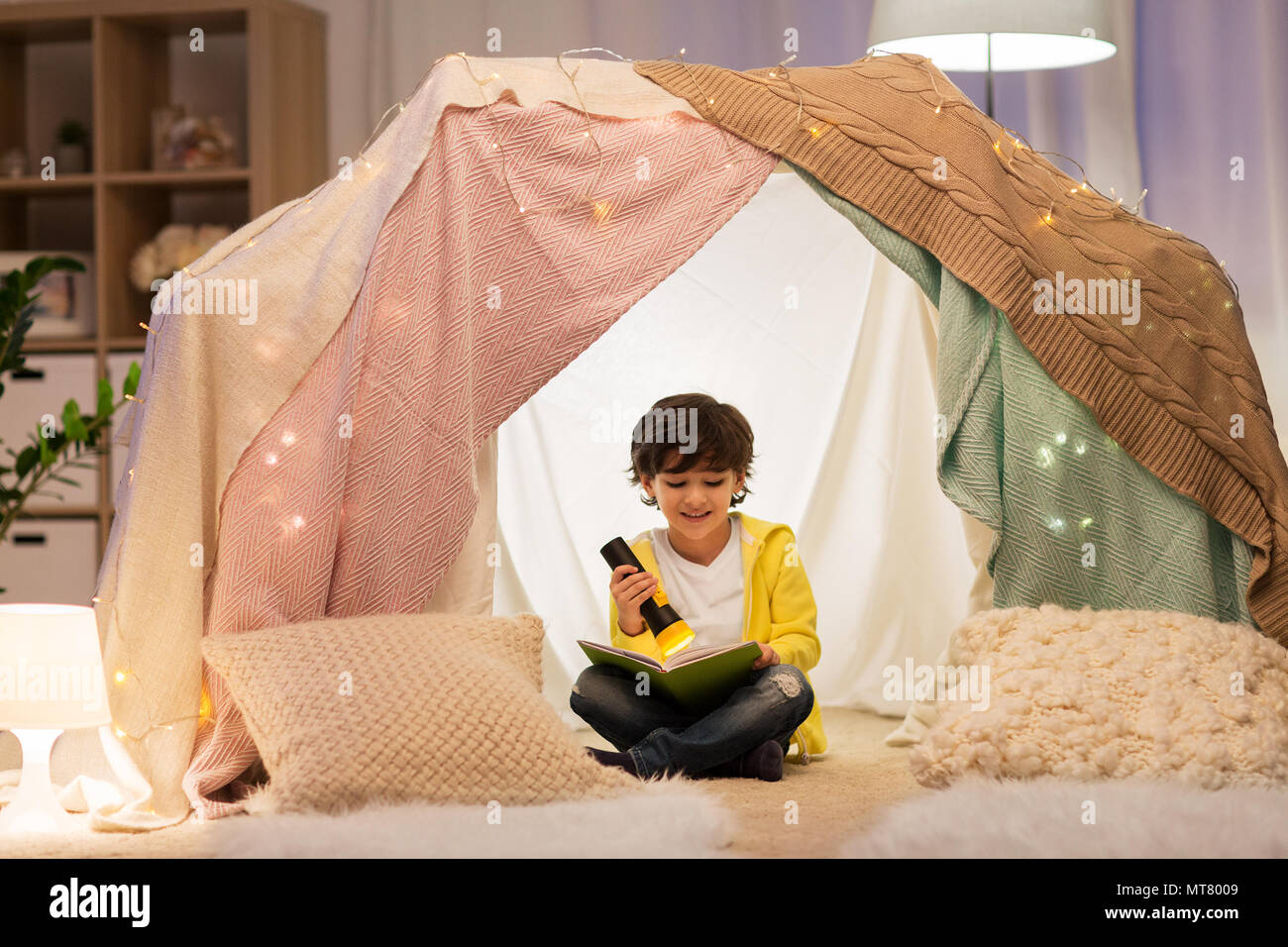 happy little boy reading book in kids tent at home Stock Photo - Alamy