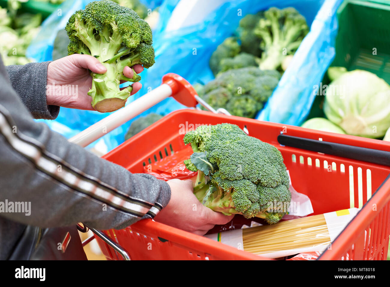 Woman buys broccoli in a grocery store Stock Photo - Alamy